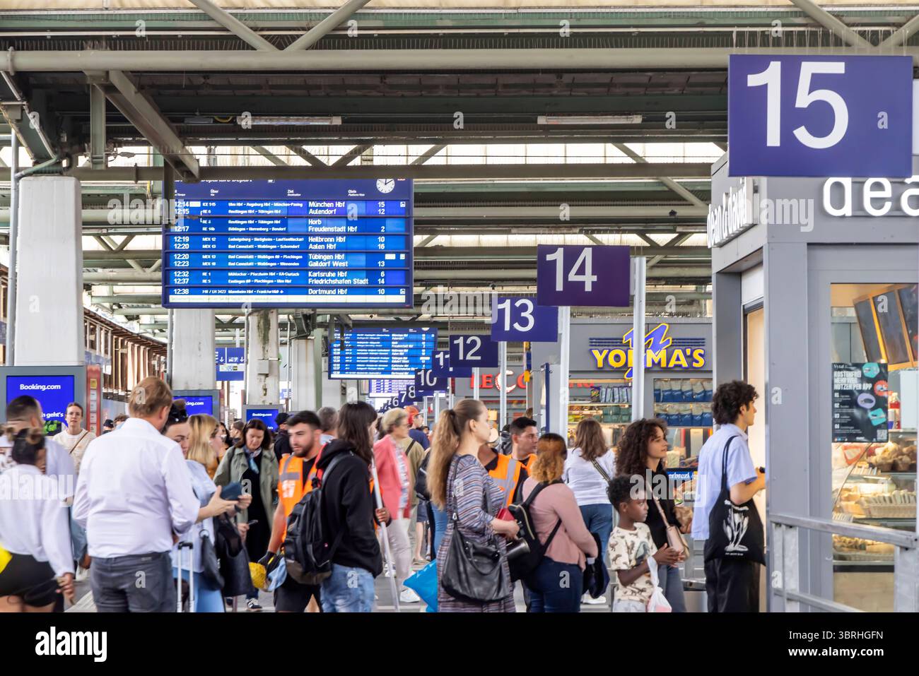 Reisende im Hauptbahnhof Stuttgart mit Bahnsteig und Fahrplananzeige ...
