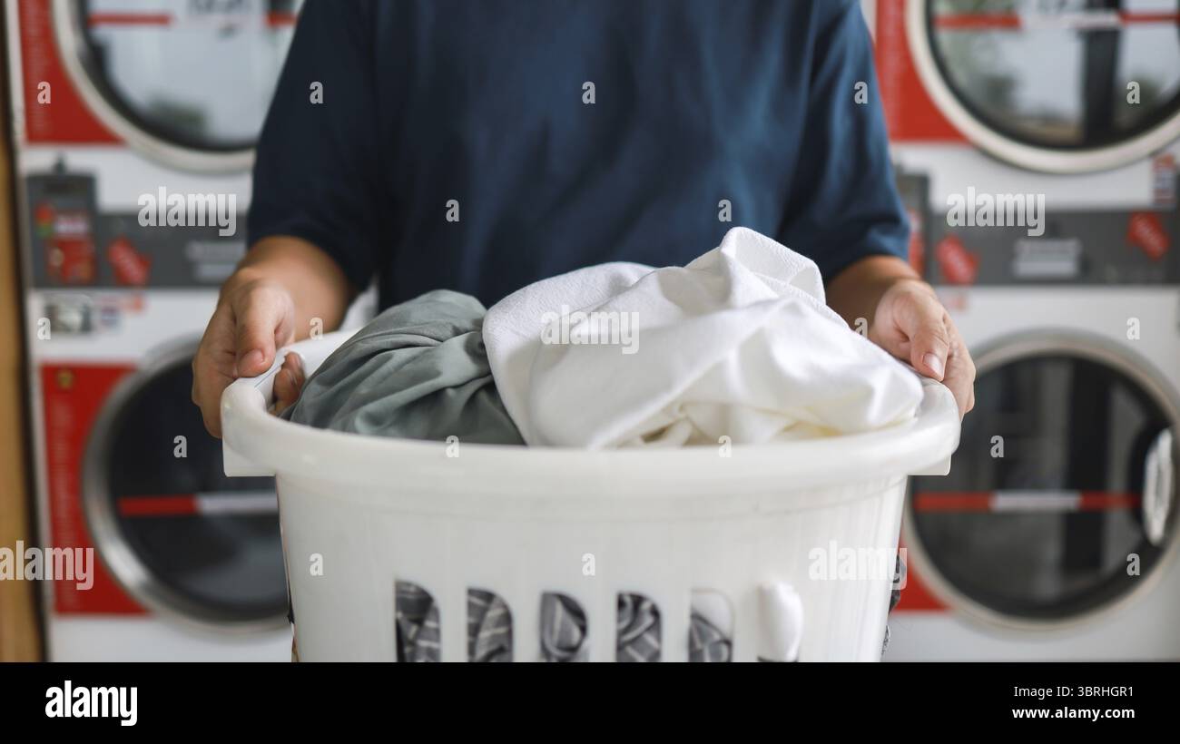 House husband with Basket and dirty laundry washed clothing in laundry ...