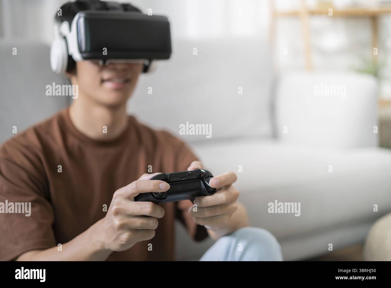 Young Asian man gamer wearing virtual reality touching air during the ...