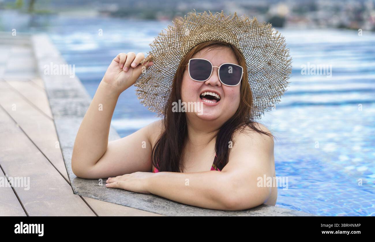 Overweight young asian woman wearing orange swimsuit and straw beach ...
