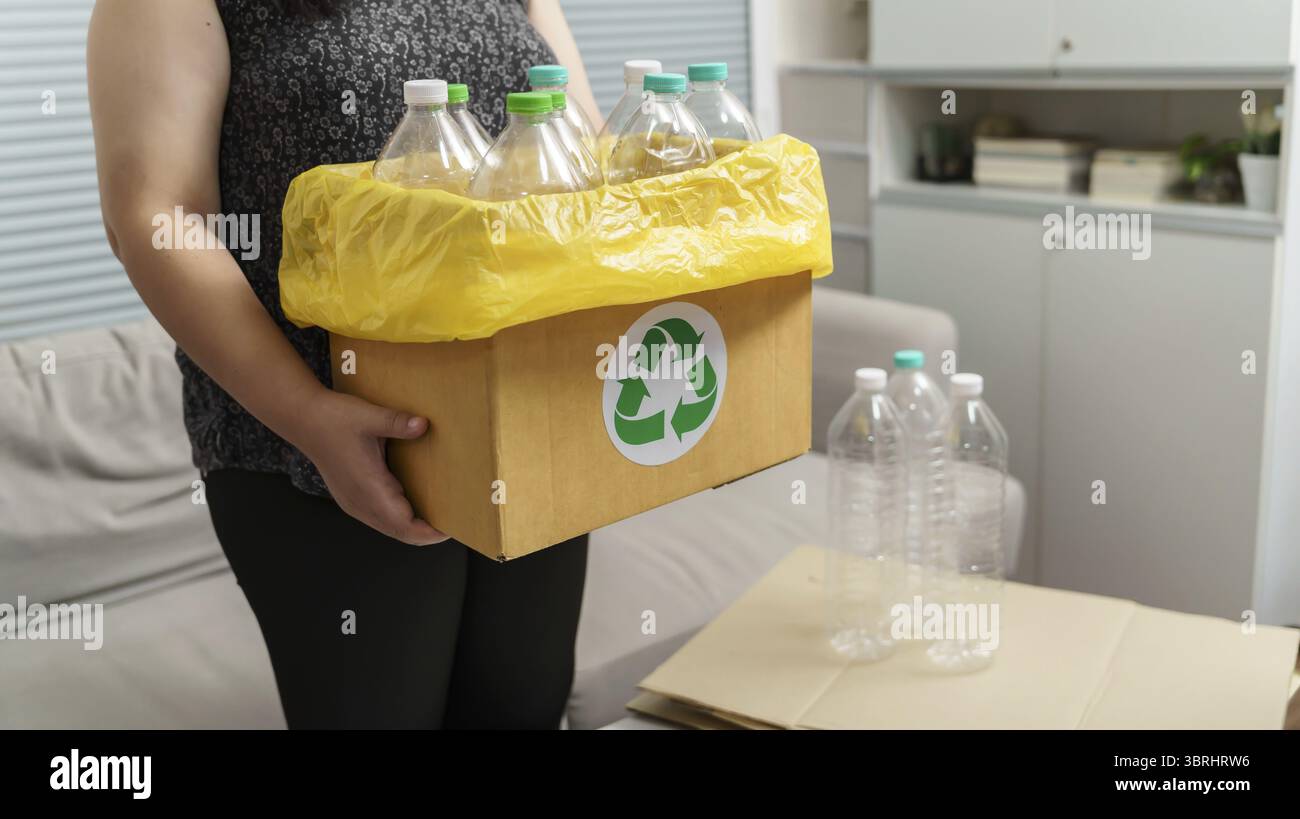 Home recycle eco green zero concept Woman throwing empty plastic bottle in recycling bin with ...