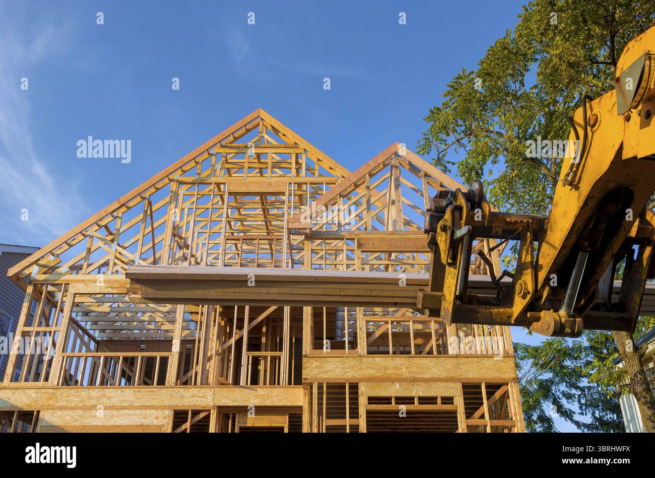 Heavy boom truck machinery is used to add the roof trusses to a timber ...