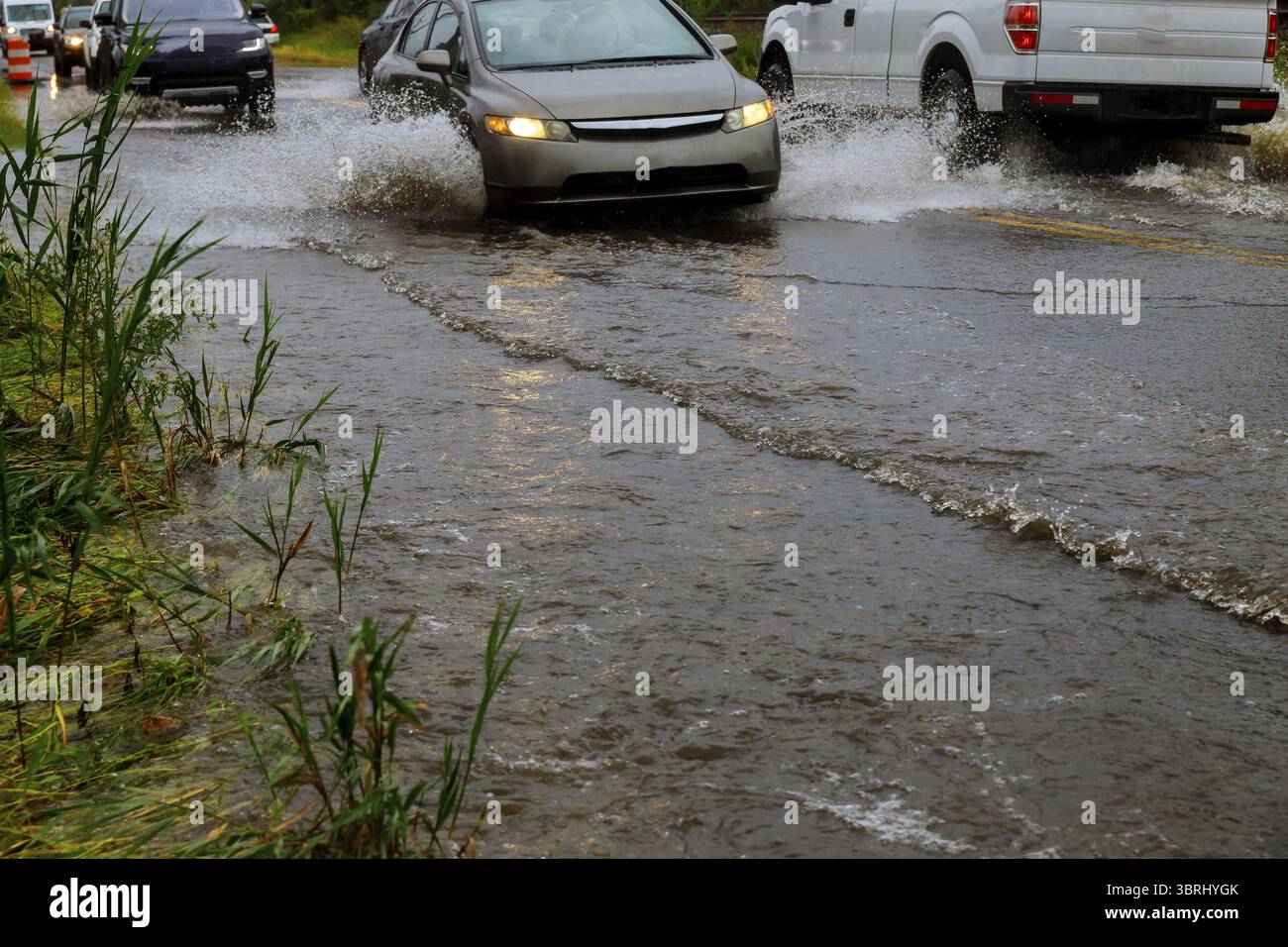 Car driving through flood water on the road during monsoon season ...