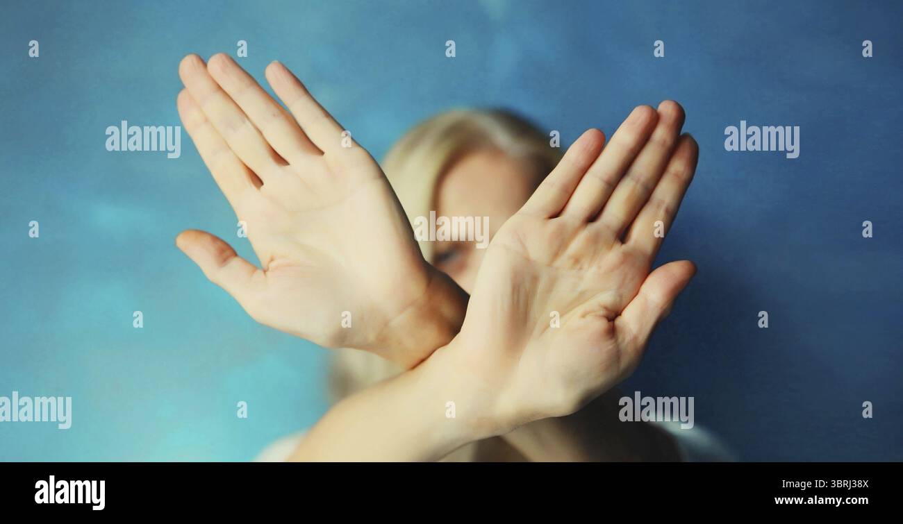 Upset young woman shows stop, no or enough sign with palm of hand ...