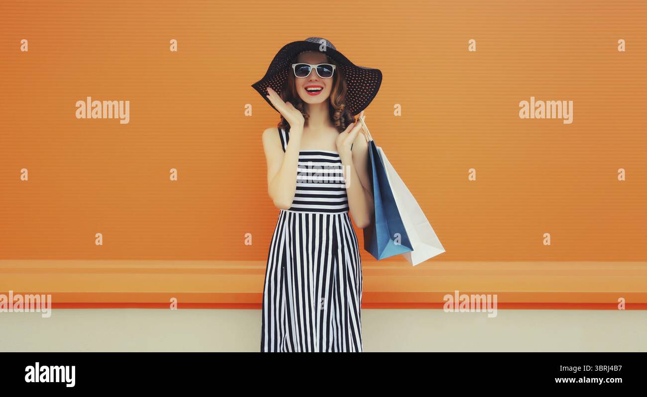 Happy emotional surprised young woman with shopping bags wearing black ...