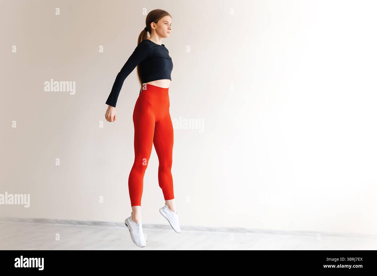 Active healthy woman doing cardio exercises and jumping in front of ...