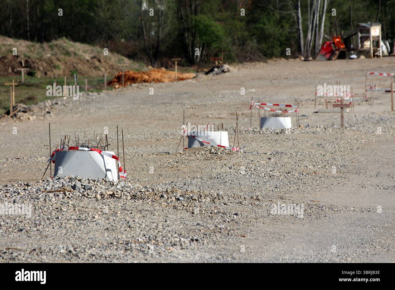 Multiple concrete foundation pillars with protruding steel rebar are ...