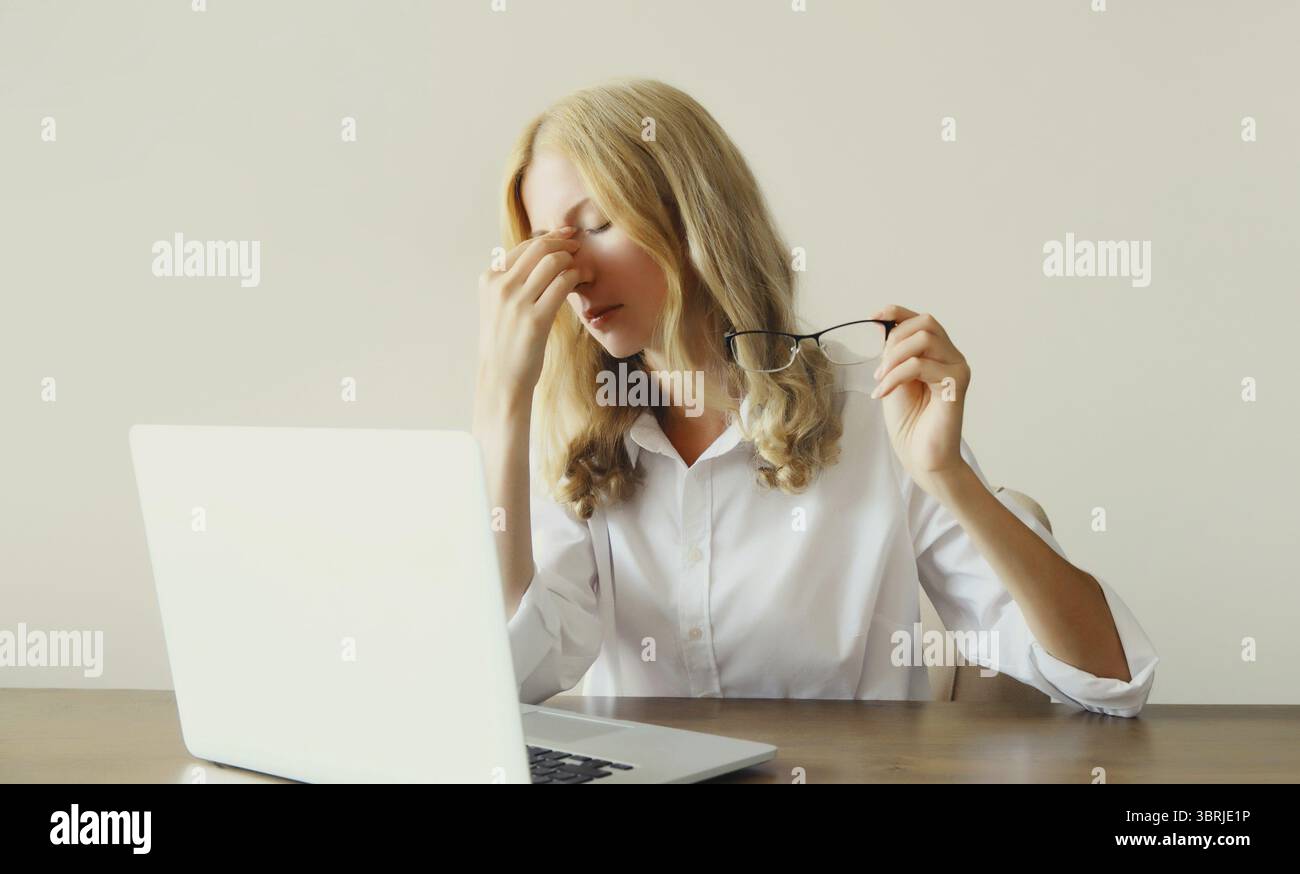 Tired overworked woman employee suffering from headache, rubbing her ...