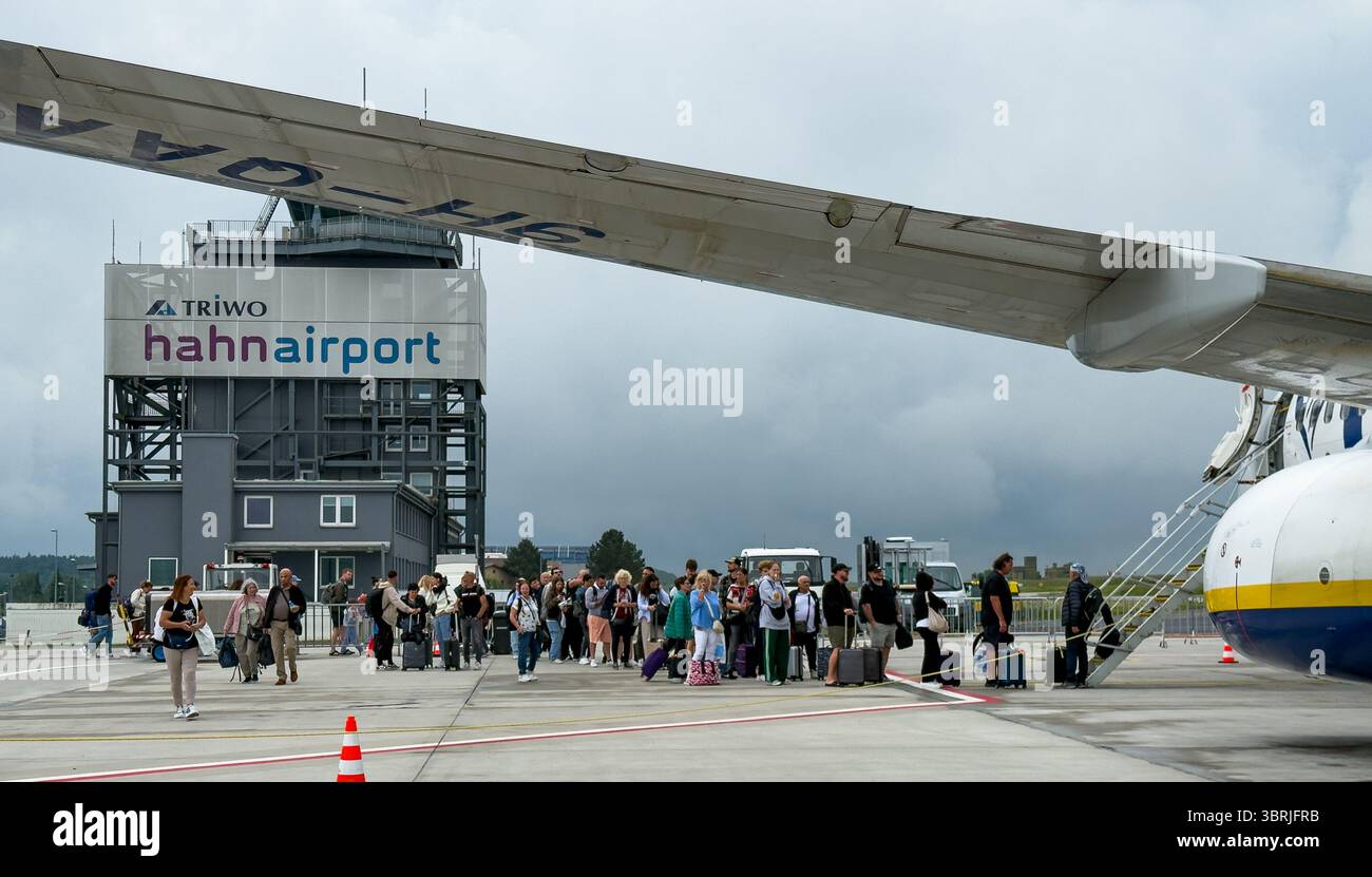 HAHN, GERMANY - JUNE 1, 2025 - Tourists walking towards airplane stairs ...