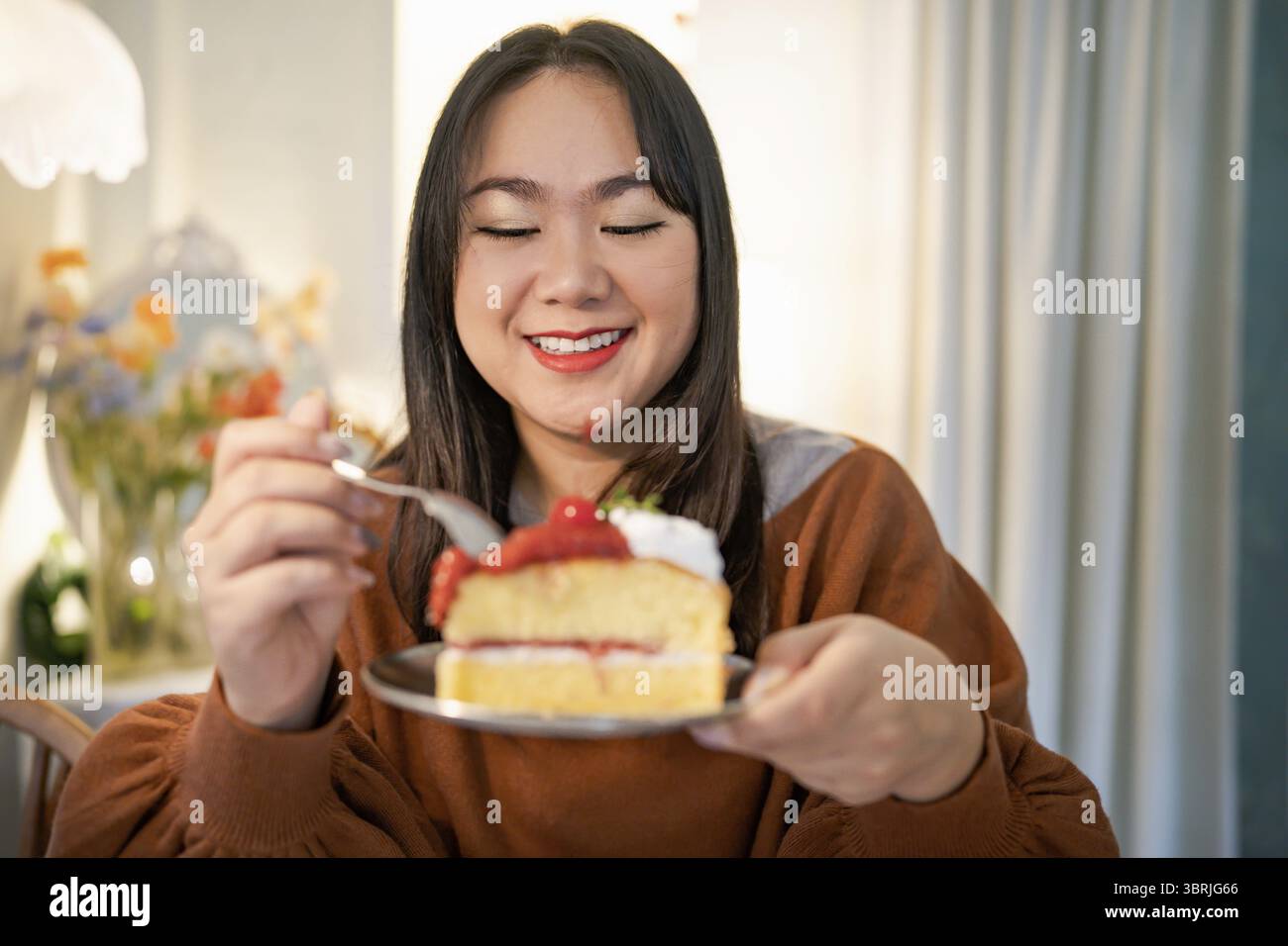 Beautiful Asian woman eating tasty cake. Teen girl eating the cake ...