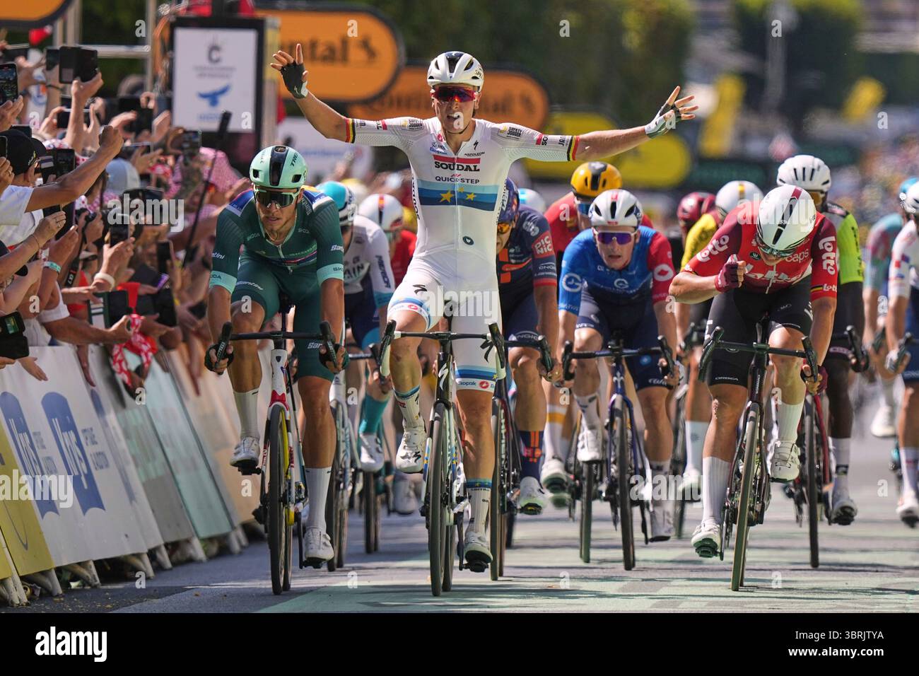 Stage winner Belgium's Tim Merlier celebrates as he crosses the finish ...