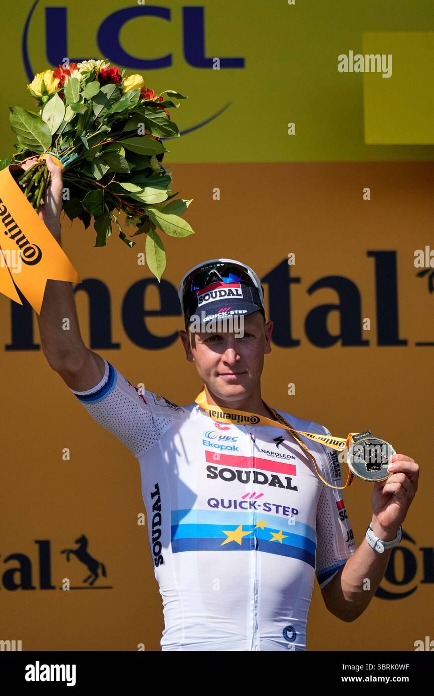 Stage winner Belgium's Tim Merlier celebrates on the podium after the ...