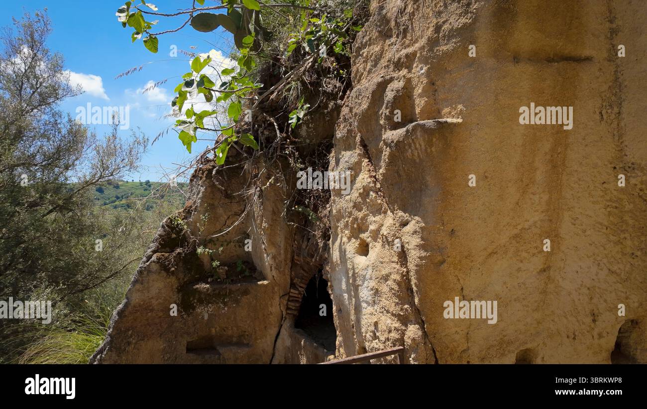 Sandstone caves carved into a cliff face in Zungri, Calabria, offer a ...