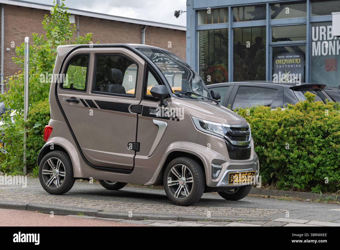 A compact and modern two-seater electric microcar (brommobiel) parked ...