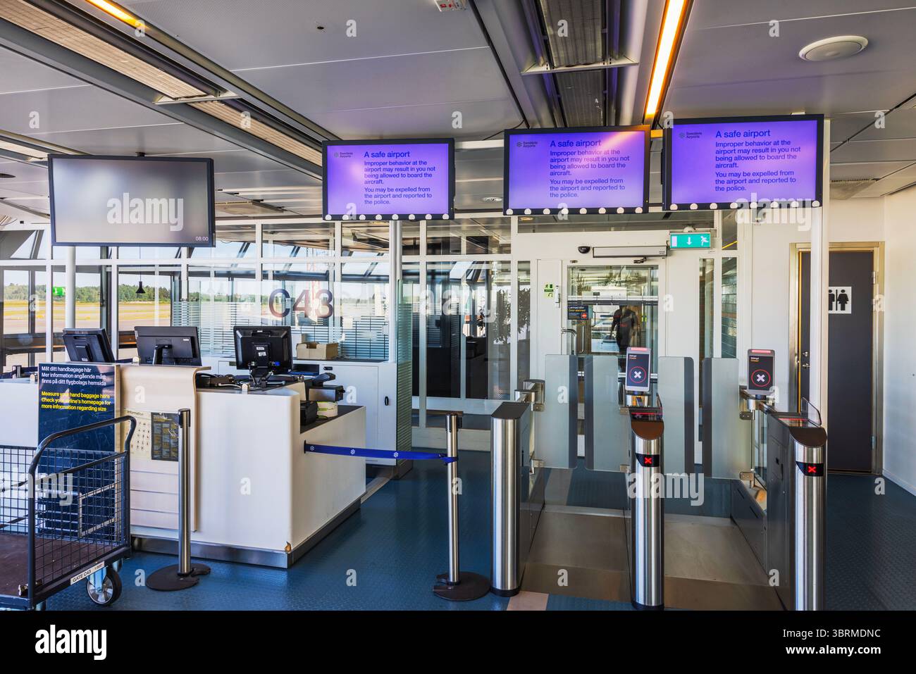 Empty airport boarding gate with turnstiles, monitors, check-in ...