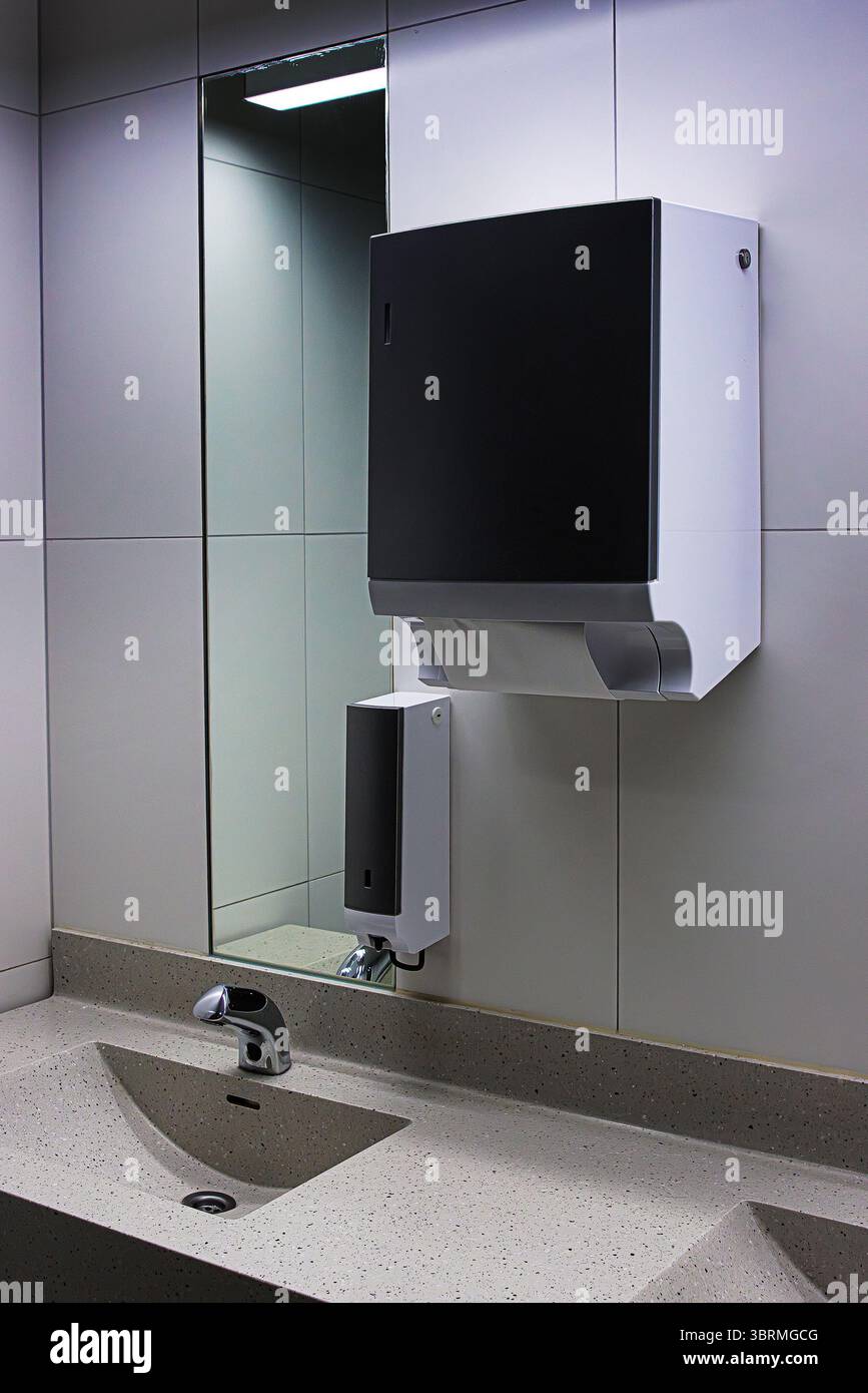Interior of a modern public restroom with sink, chrome automatic faucet ...