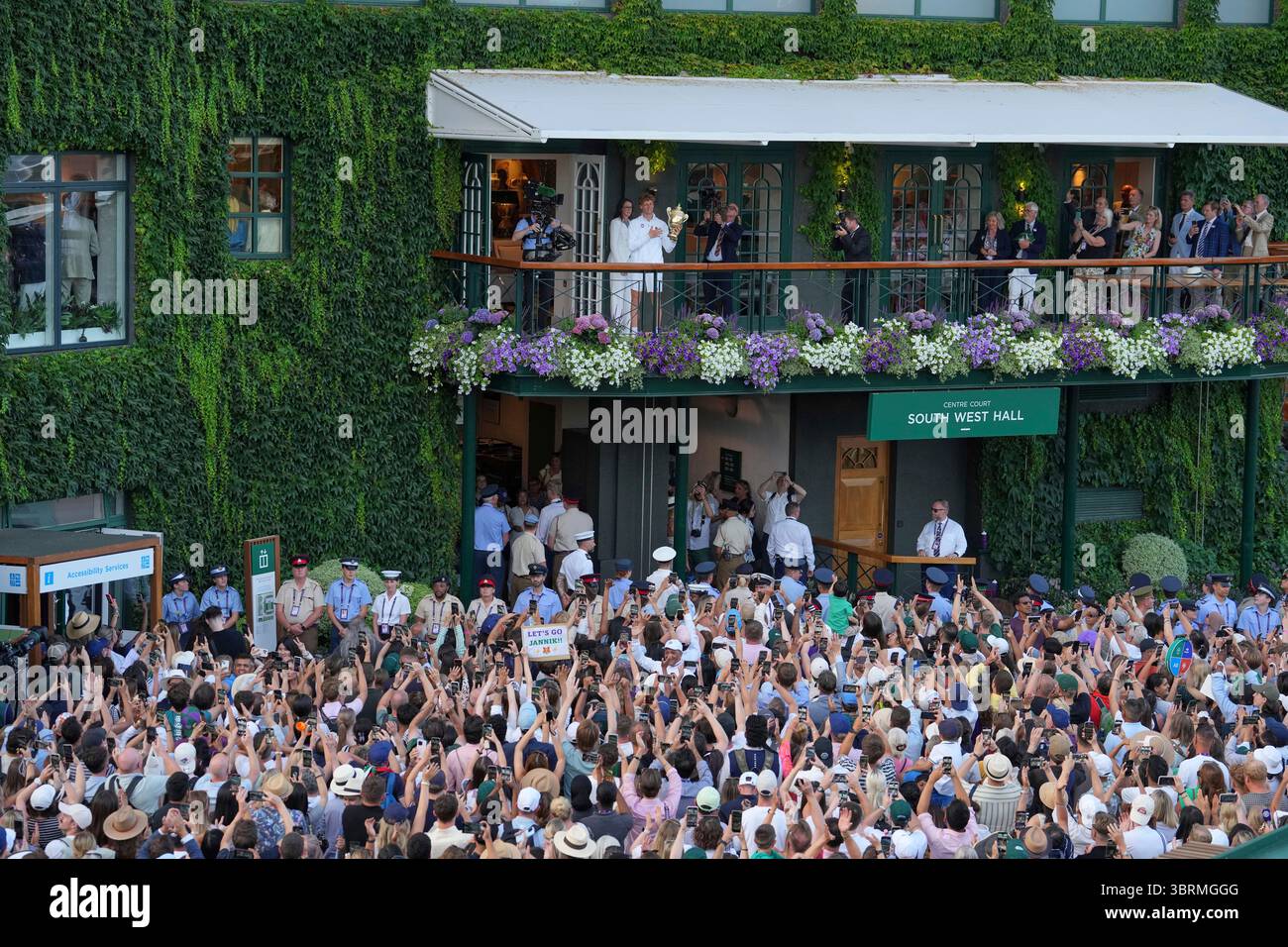 Italy's Jannik Sinner shows the trophy from the balcony of Centre Court ...