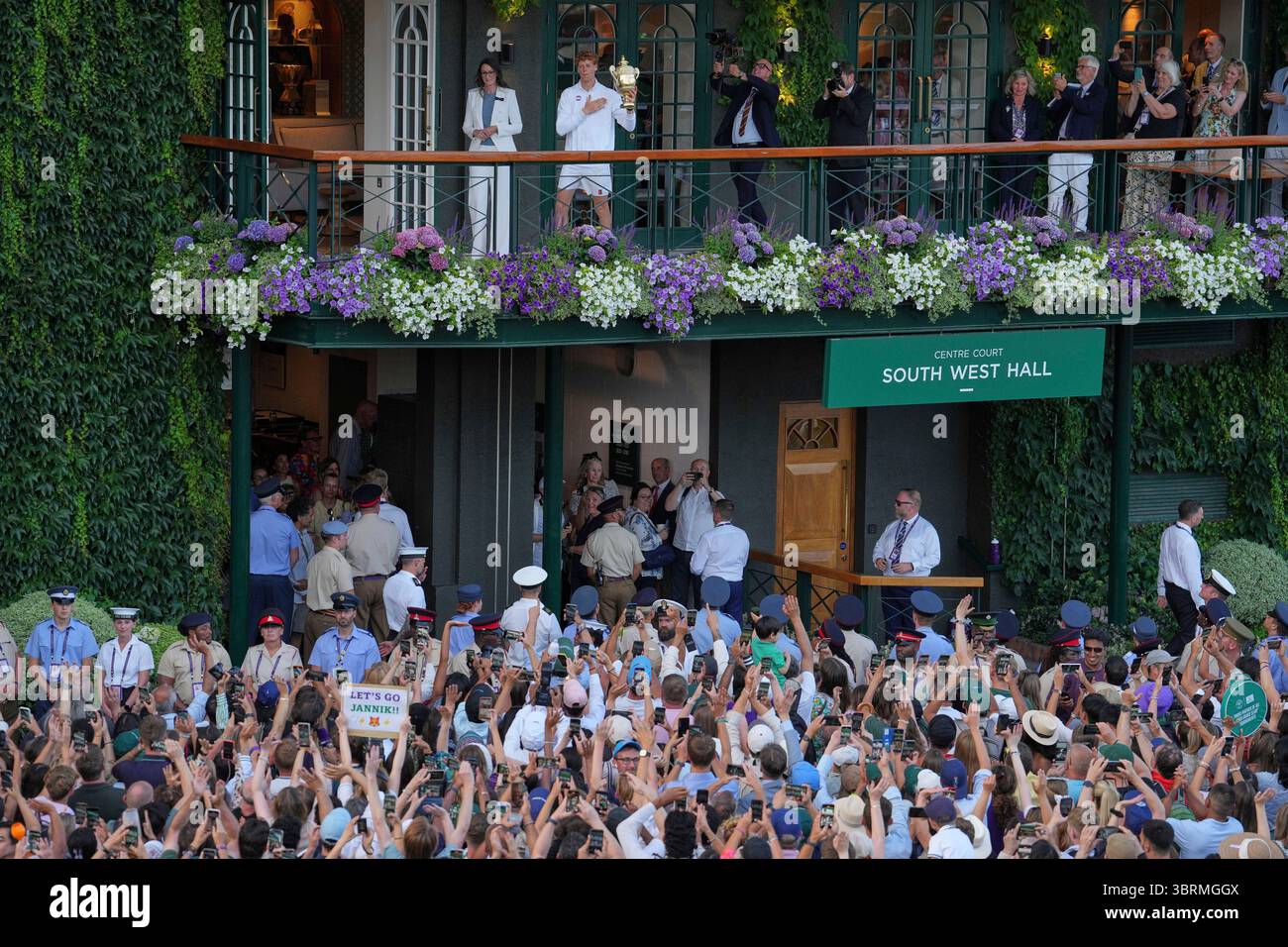 Italy's Jannik Sinner shows the trophy from the balcony of Centre Court ...