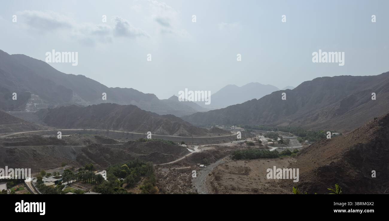 Scenic mountain landscape with winding roads and a hazy sky. Sparse ...