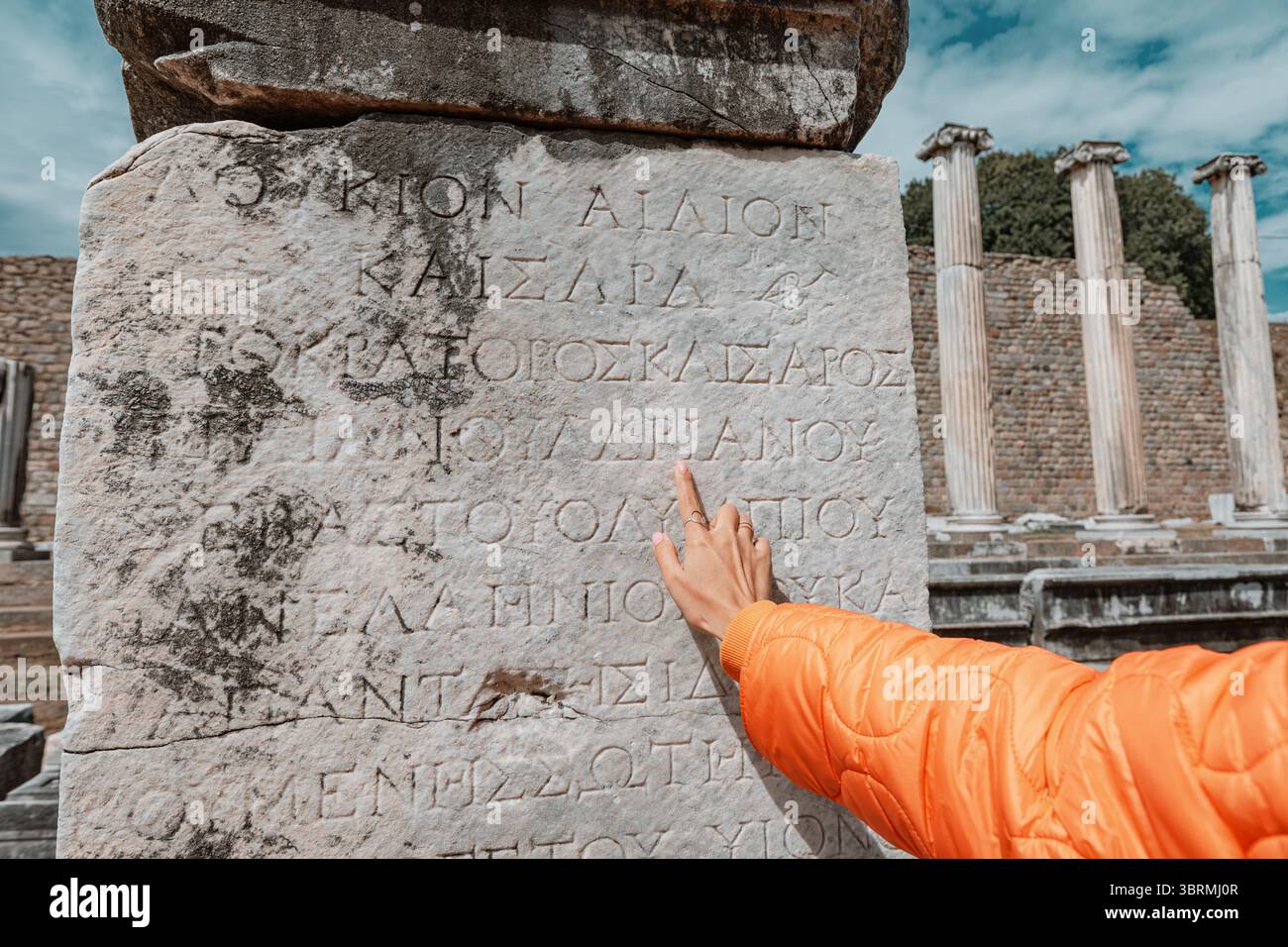 Tourist pointing finger at inscription in ancient Greek that mentions ...