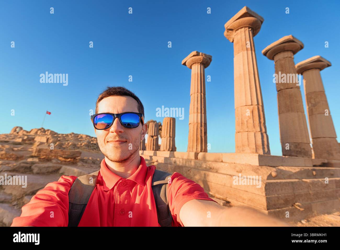 Male tourist capturing a selfie in front of ancient Greek columns at ...