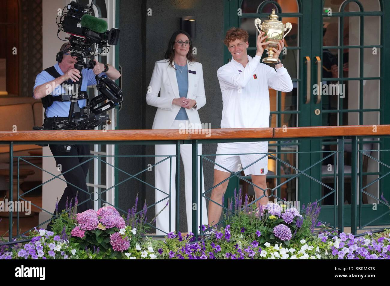 Italy's Jannik Sinner shows the trophy from the balcony of Centre Court ...