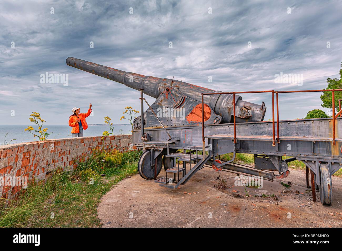 Tourist pointing at an old Turkish military cannon overlooking the ...