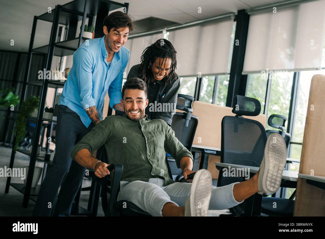 Excited diverse employees laughing enjoying funny activity at work ...