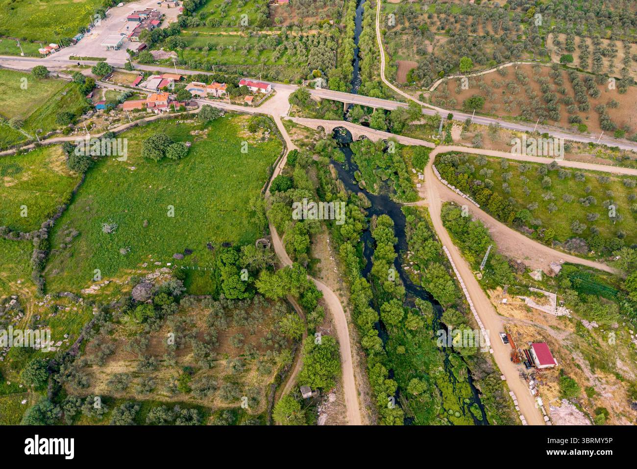 Aerial view of a river flowing near a small village and intersecting ...