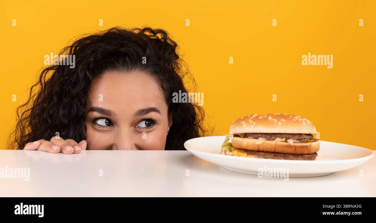 Hungry Lady Looking At Burger Peeping Out Table Stock Photo - Alamy