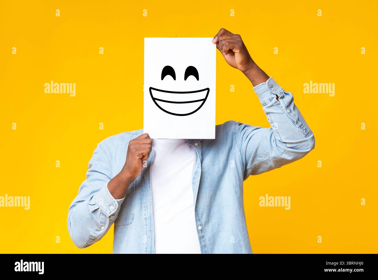 African man hiding face behind paper with drawn happy emoticon Stock ...