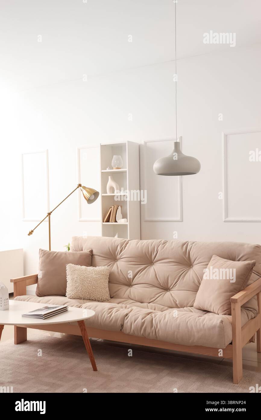 Interior of light living room with cozy white sofa and coffee table ...