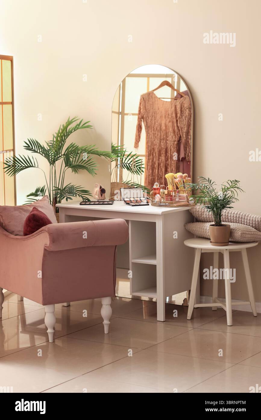 Interior of dressing room with table, makeup products and armchair ...