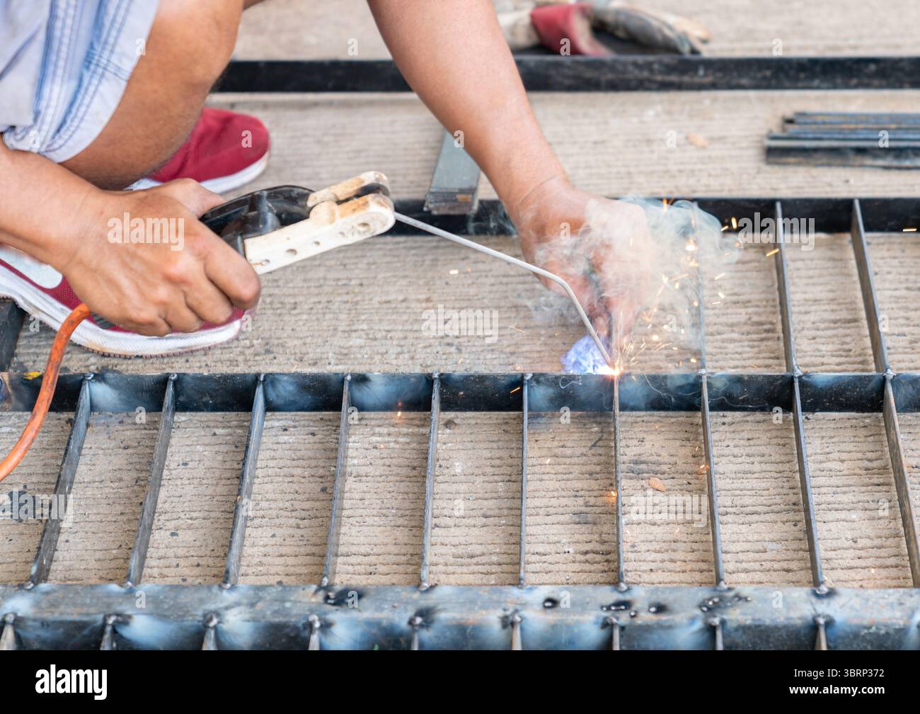 Construction workers are welding the drainage trench cover grate into ...
