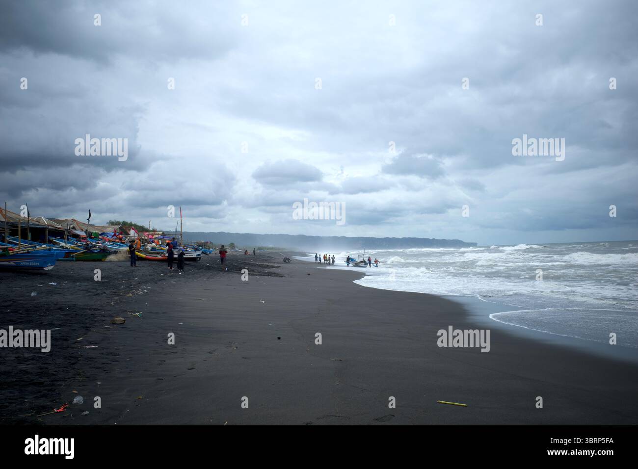 Visitors and fishing boats at Depok Beach, Yogyakarta, Indonesia with ...