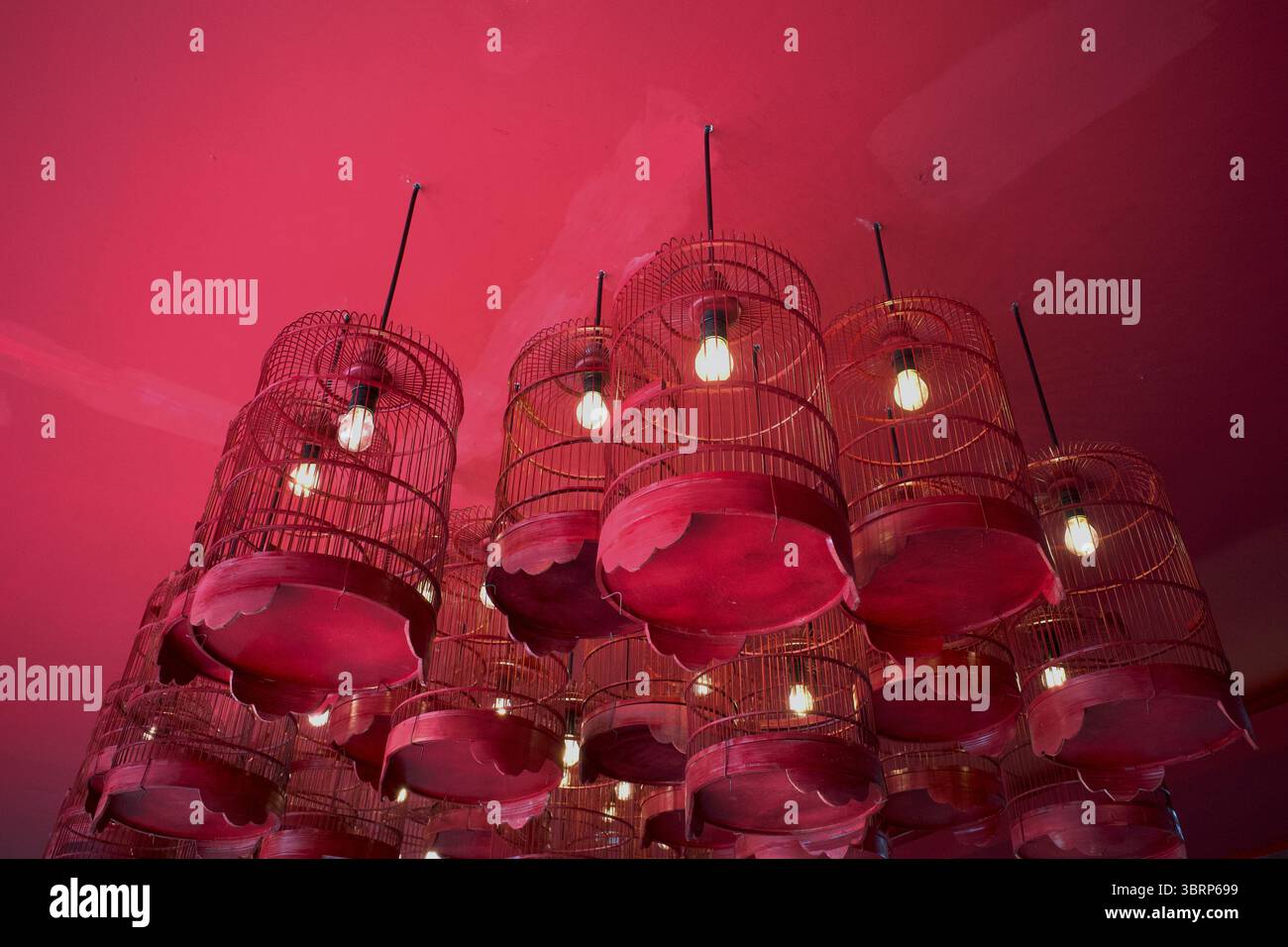 Light idea bulps in the red cages with red wall background. Business ...