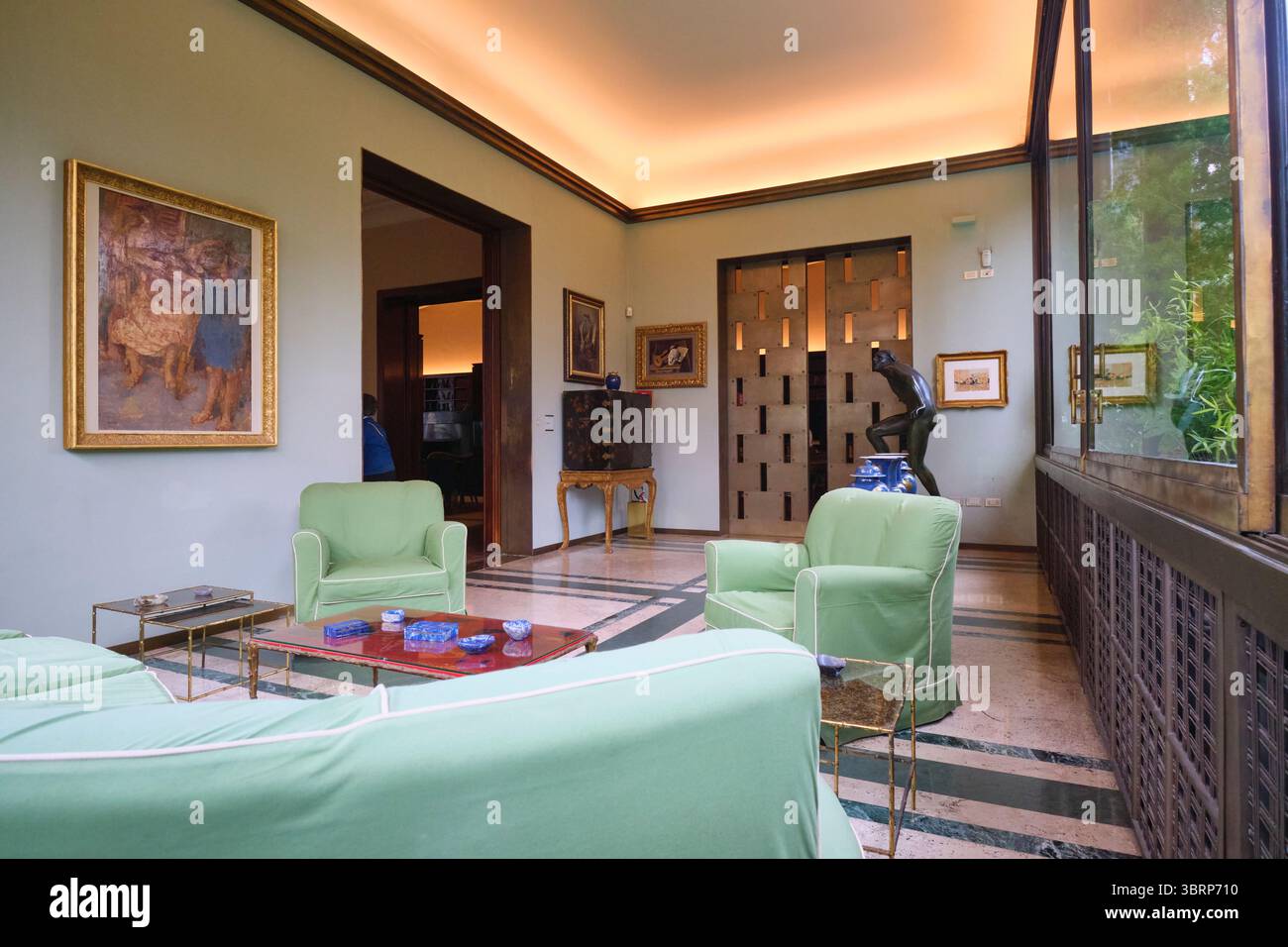 View of the enclosed sun room with green furniture. At the Italian ...