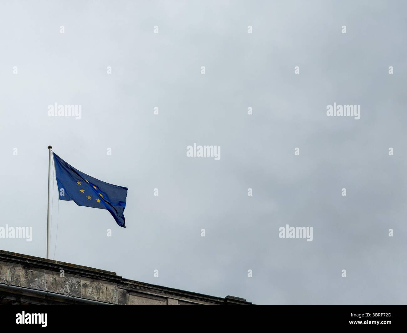The European Union flag waving in the wind with a background of grey ...
