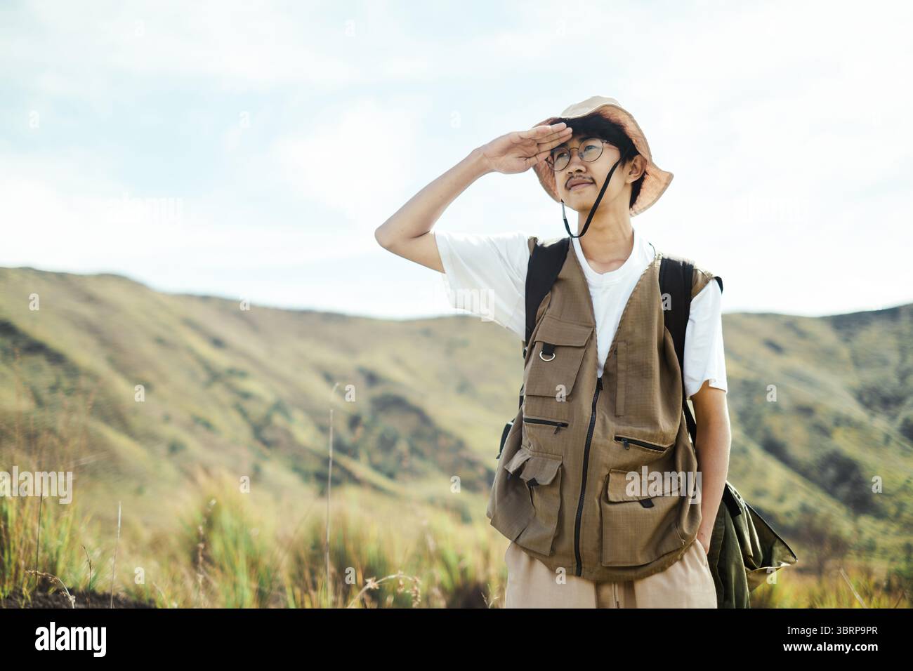 Smiling Southeast Asian man wearing bucket hat, glasses, white t-shirt ...