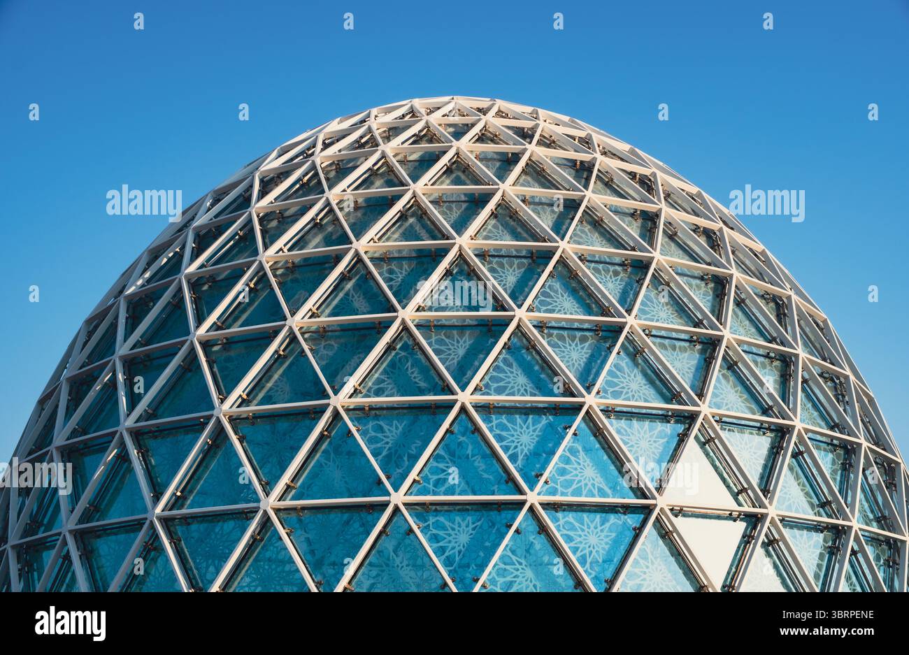 Close-up view of a modern geodesic glass dome structure against a clear ...