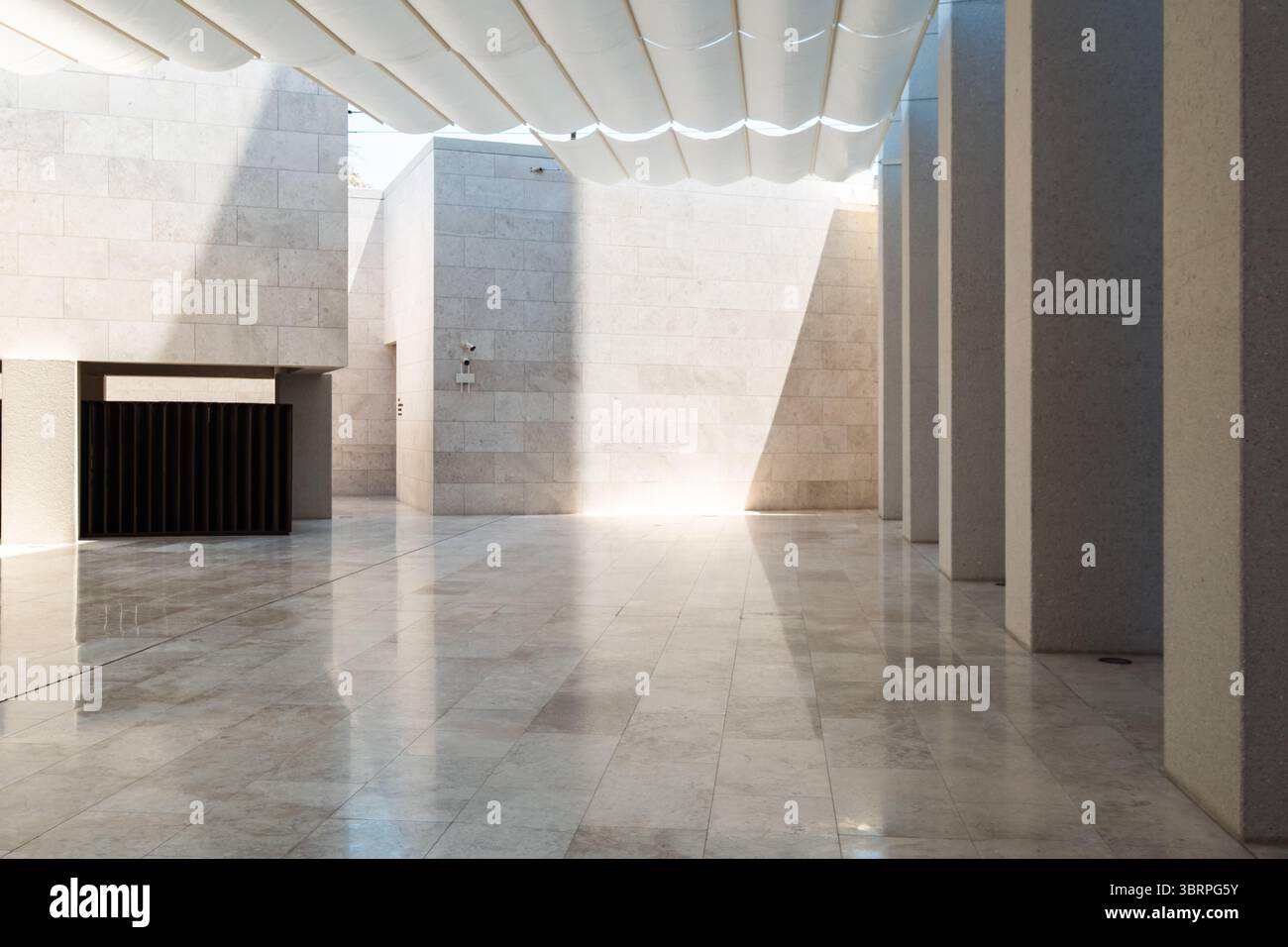 Sunny marble corridor with modern architecture, featuring tall columns ...