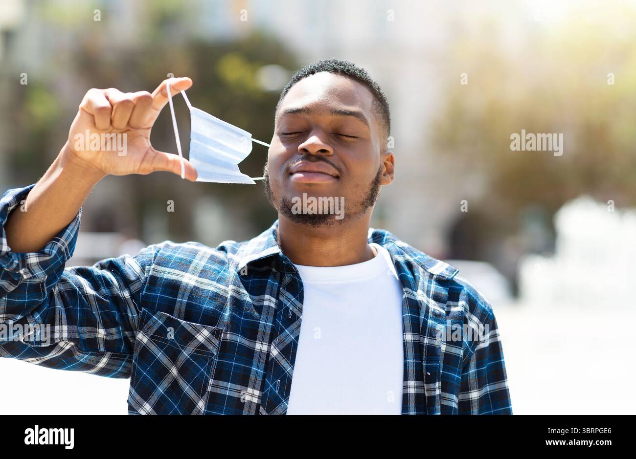 Portrait of afro man taking off mask and breathing Stock Photo - Alamy