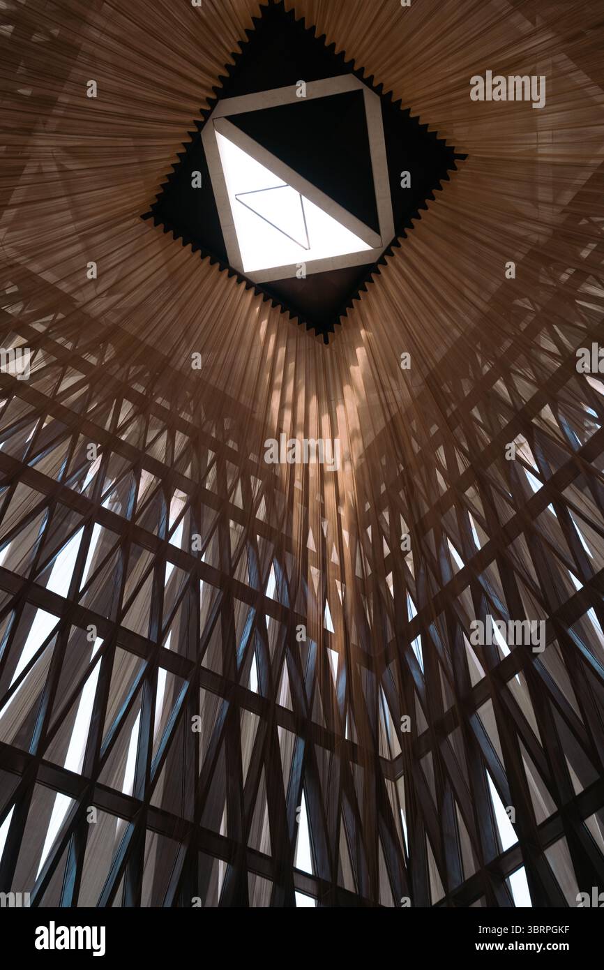 Geometric ceiling with a skylight casting angular shadows in a modern ...