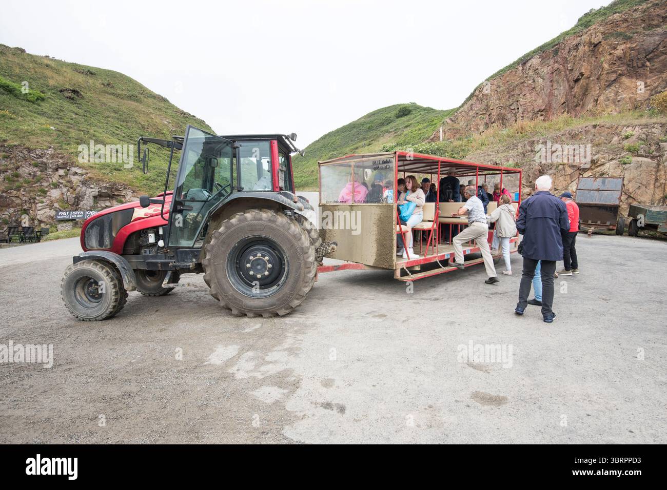 Tractor and trailer ferrying tourist up the hill from ferry hi-res ...
