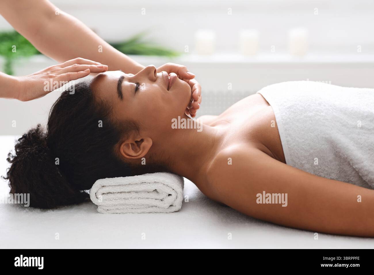 Facial spa massage for young african lady Stock Photo - Alamy