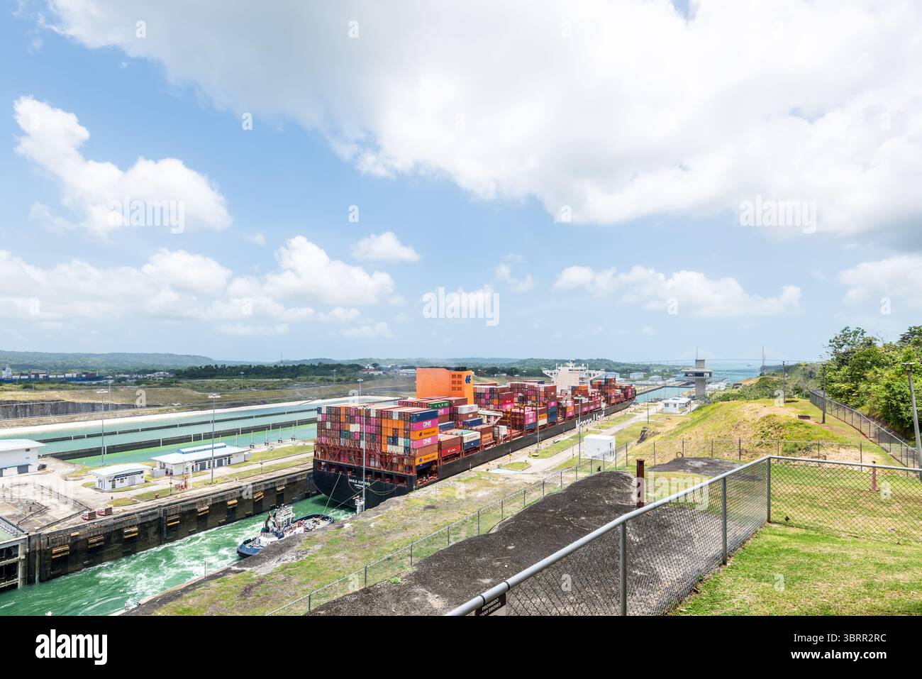 Colon, Panama - April 13, 2024: A tugboat guides a container ship ...