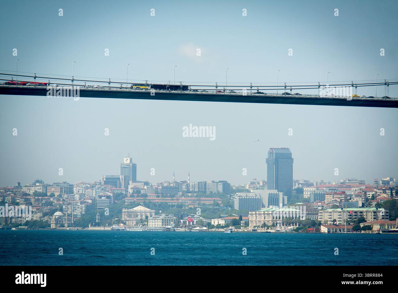 The vibrant skyline of Istanbul showcases a majestic bridge overhead ...