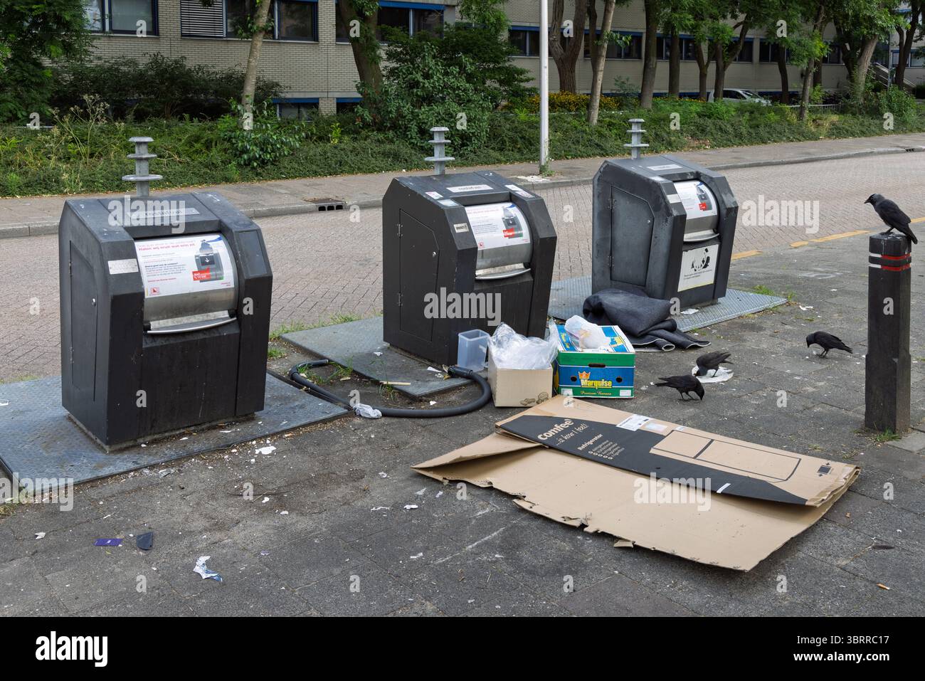 Three public underground waste containers, one with overflowing trash ...