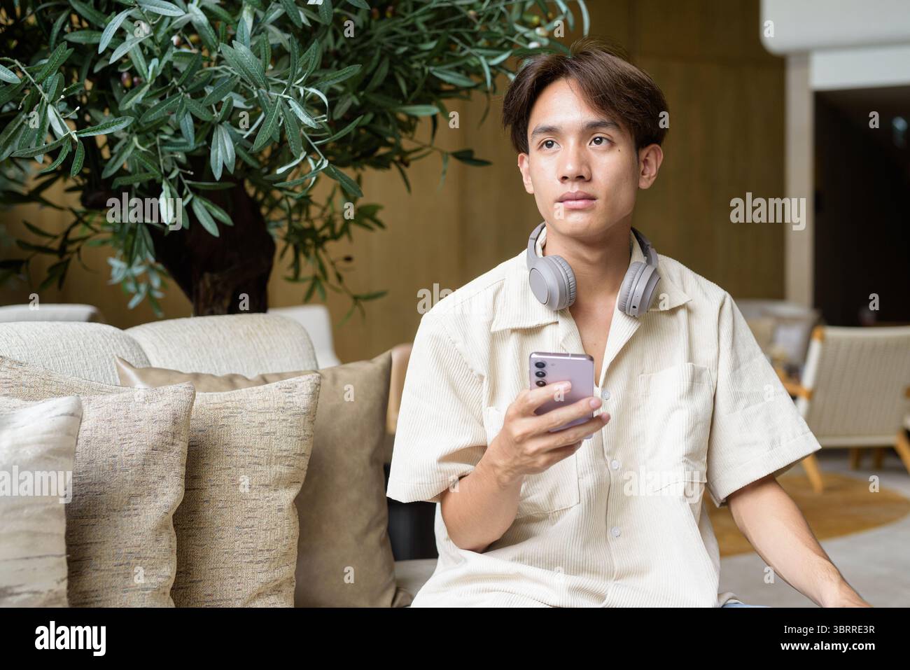 Non binary cute Asian student man sitting in modern coffee shop Stock ...