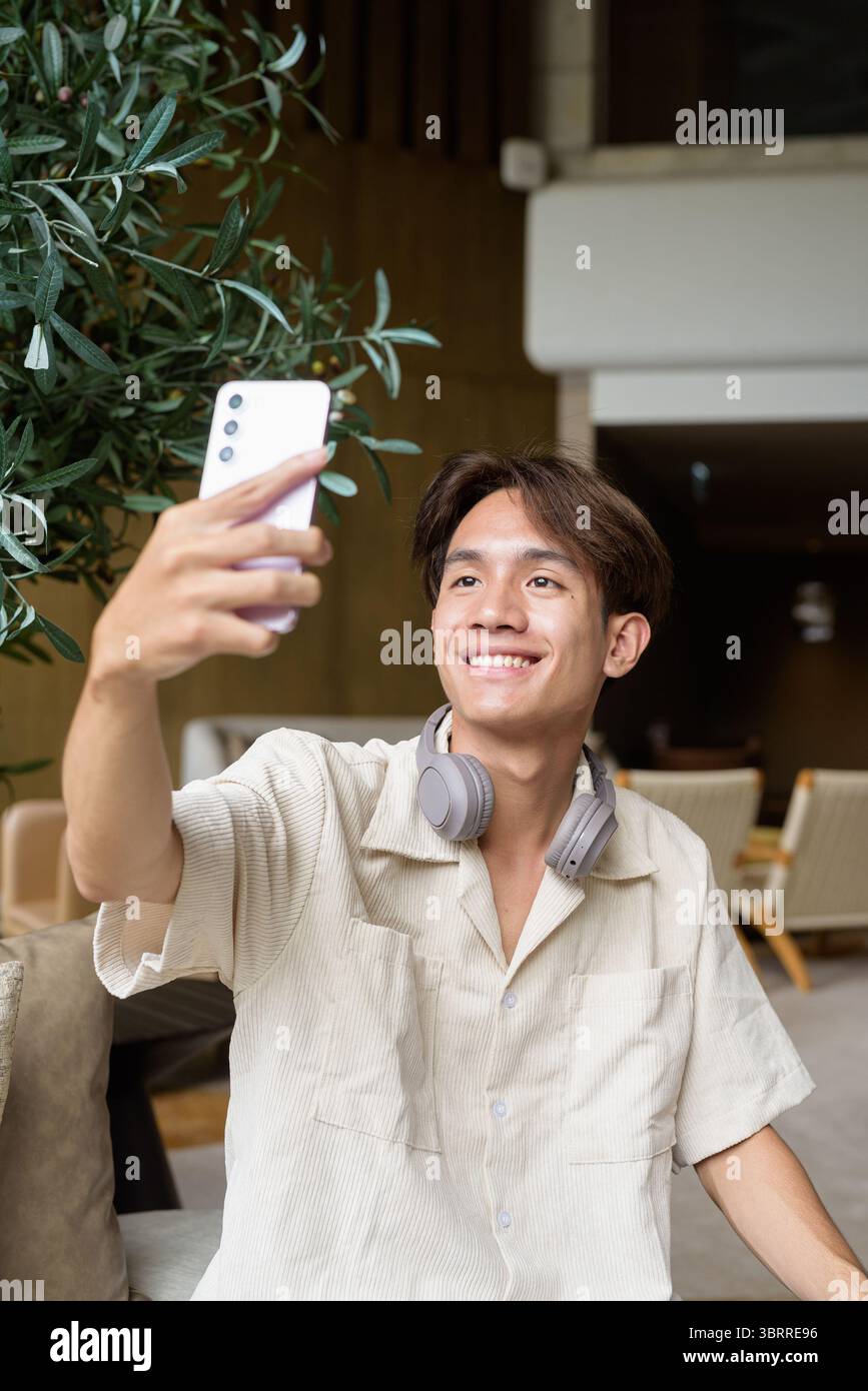 Non binary cute Asian student man sitting in modern coffee shop Stock ...